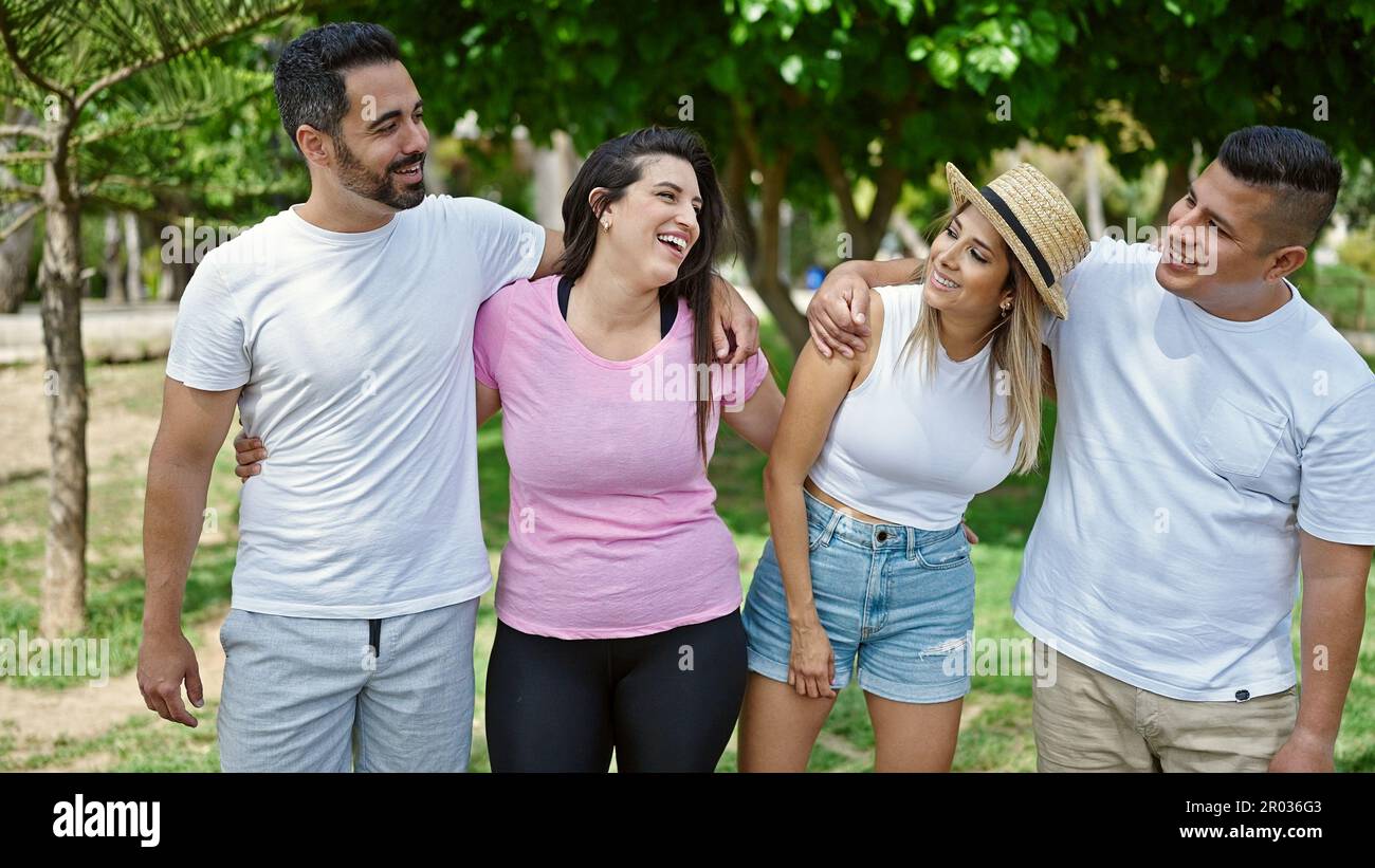 Group of people hugging each other smiling at park Stock Photo - Alamy