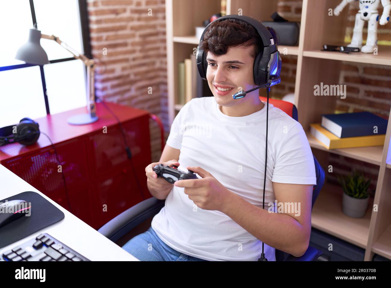 Non binary man streamer playing video game using joystick at gaming ...