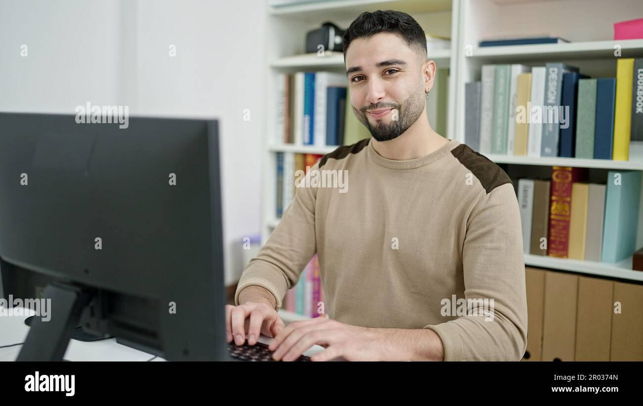 Young arab man student using computer studying at university classroom ...