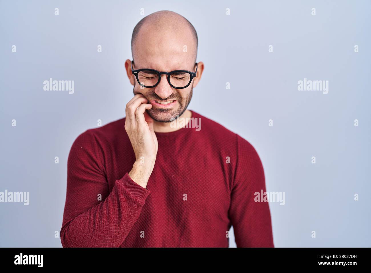 Young bald man with beard standing over white background wearing ...