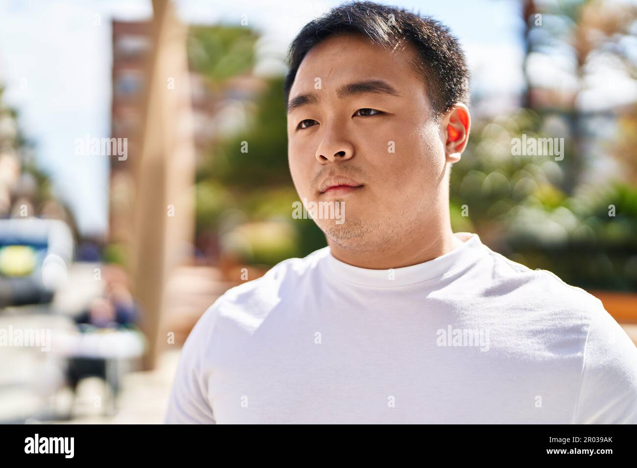 Young chinese man standing with relaxed expression at street Stock ...