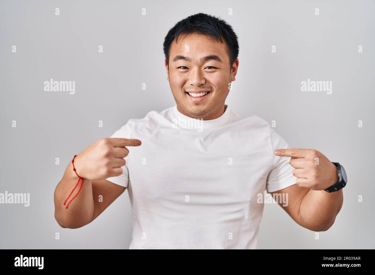 Young chinese man standing over white background looking confident with ...