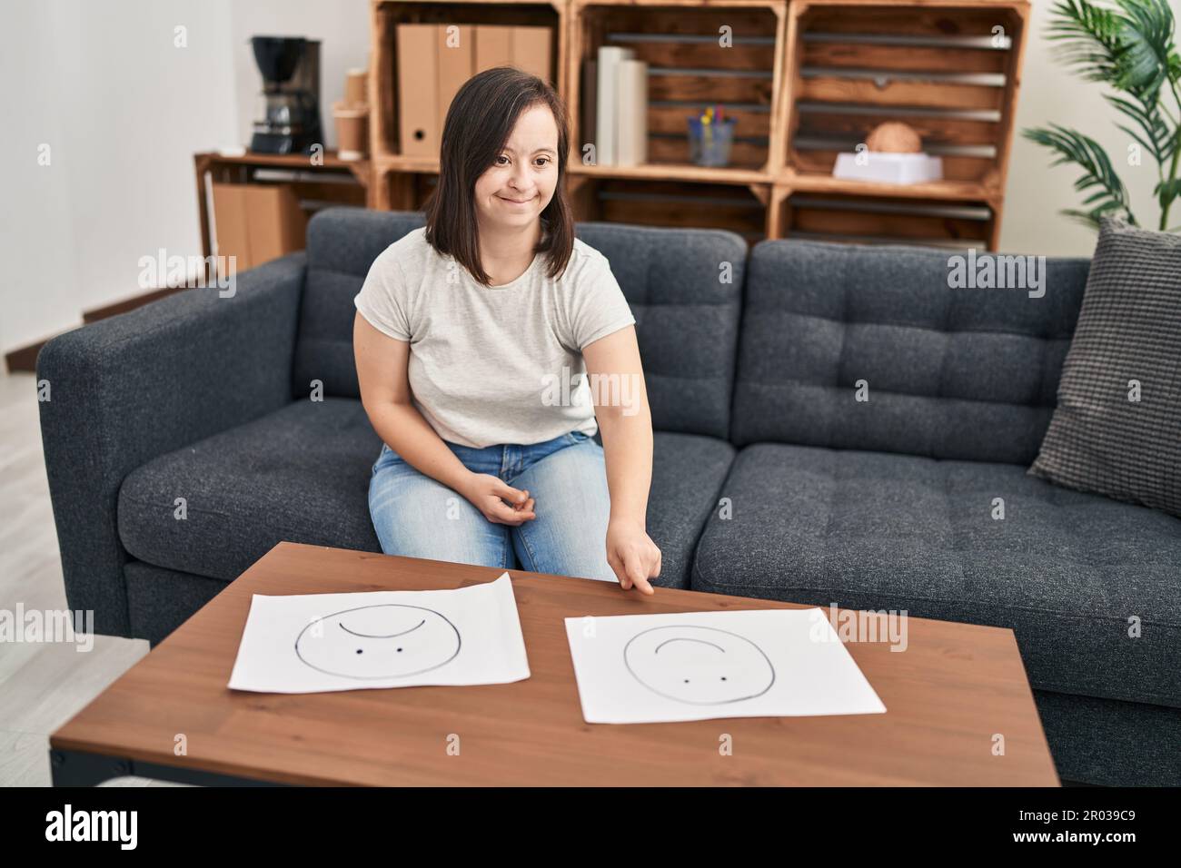 Down syndrome woman patient having psychology session pointing to happy ...