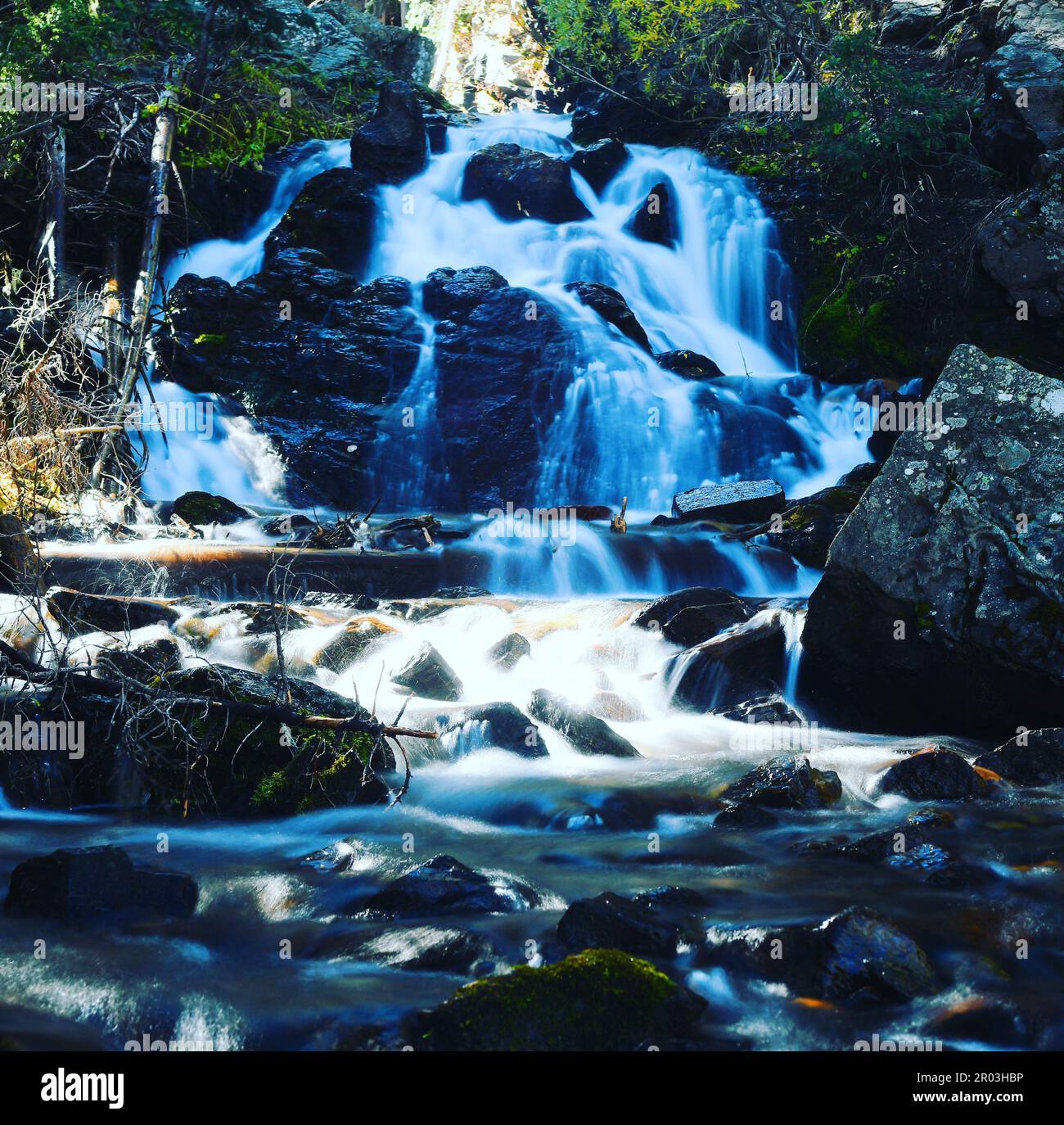 A picturesque Red River waterfall cascades down a rocky cliff face ...