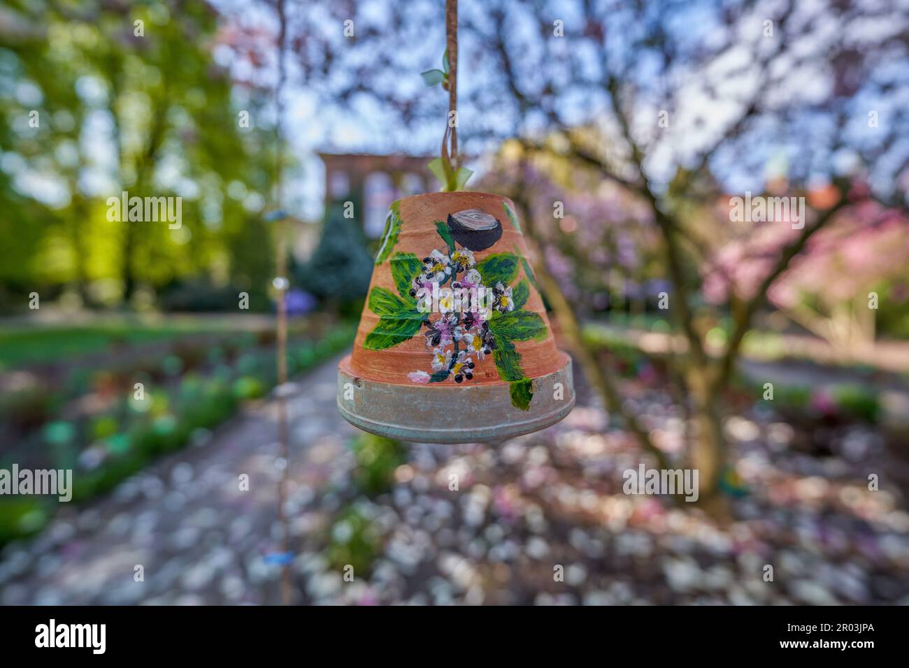 Hand painted ceramic flower pot dangling on magnolia tree branch Stock ...
