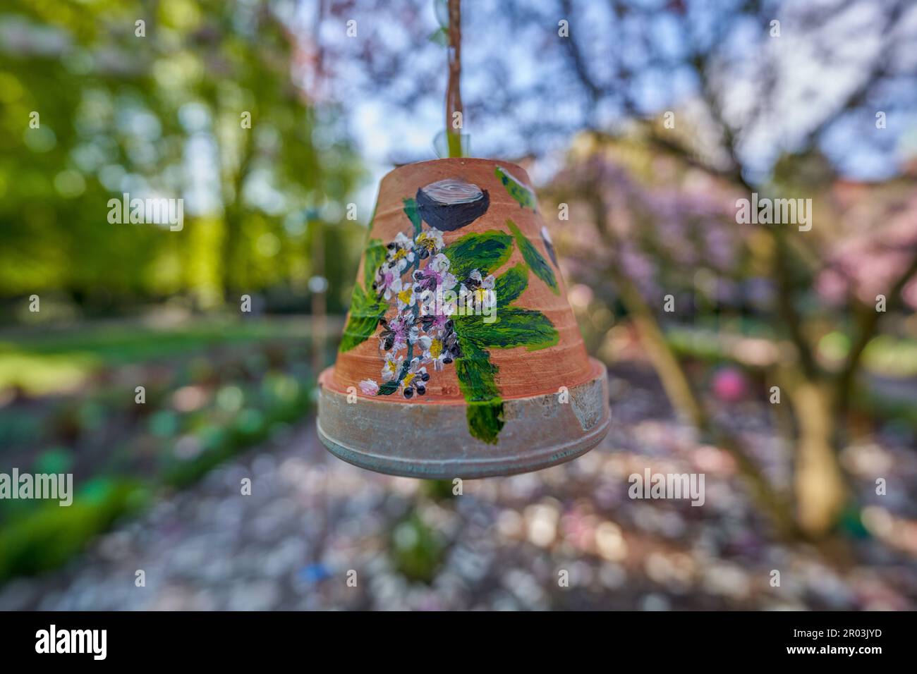 Hand painted ceramic flower pot dangling on magnolia tree branch Stock ...