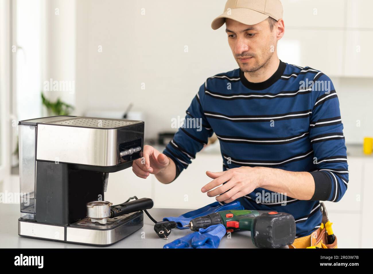 professional young worker fixing coffee machine Stock Photo - Alamy