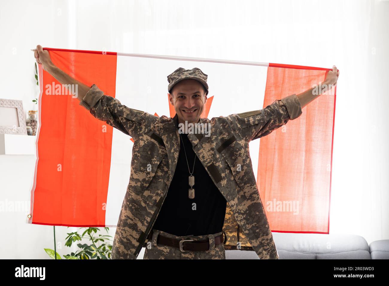 partial view of man in military uniform holding canada national flag ...