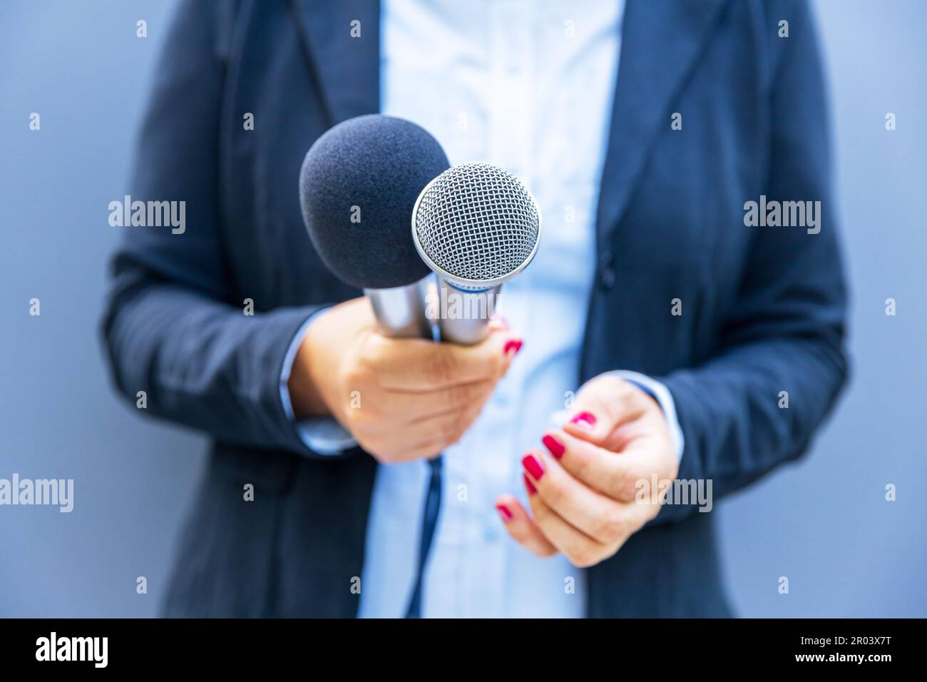 Female reporter holding microphone during media interview. Freedom of ...