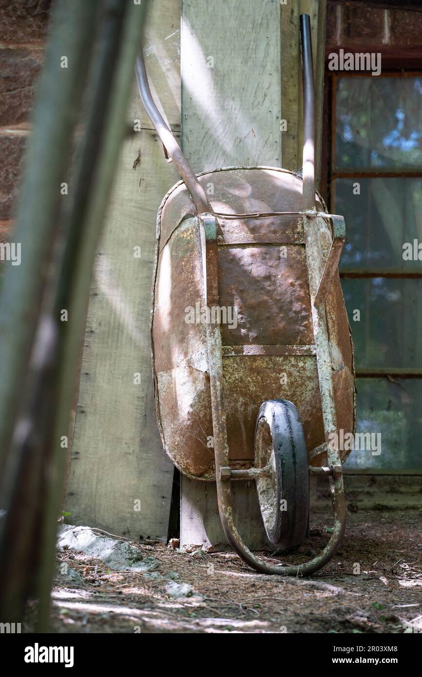 Old rusty wheelbarrow on the house wall Stock Photo - Alamy