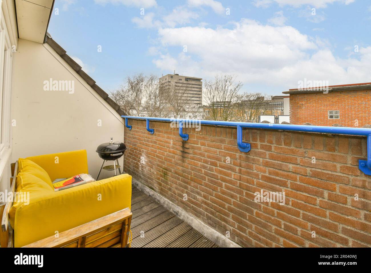 an outside area with a couch, chair and brick wall that has been ...