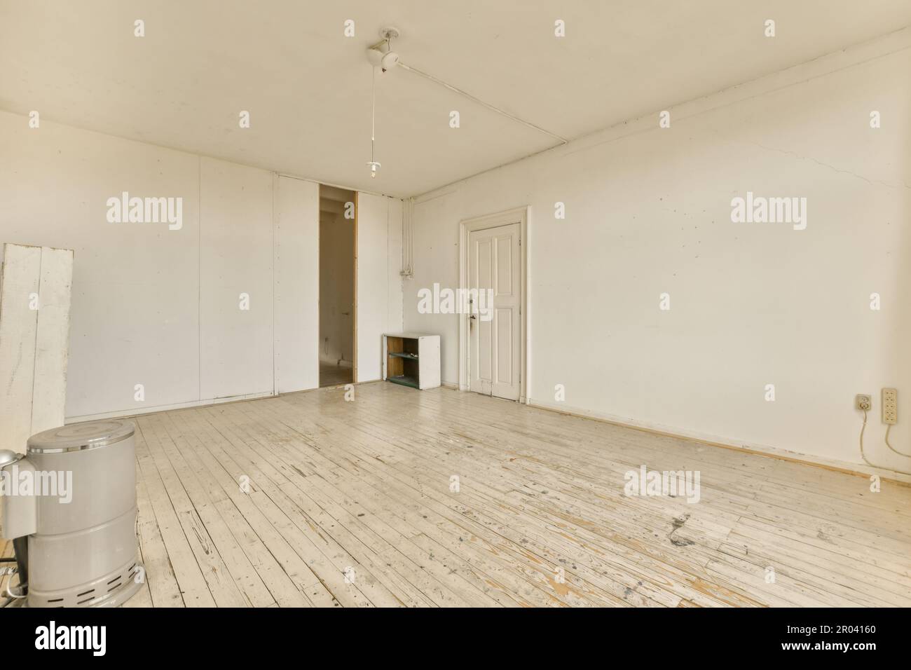 an empty room with white walls and wood flooring on one side, there is ...