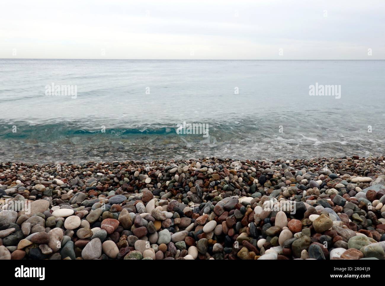 Beach with many small smooth pebble and clean calm transparent sea till ...