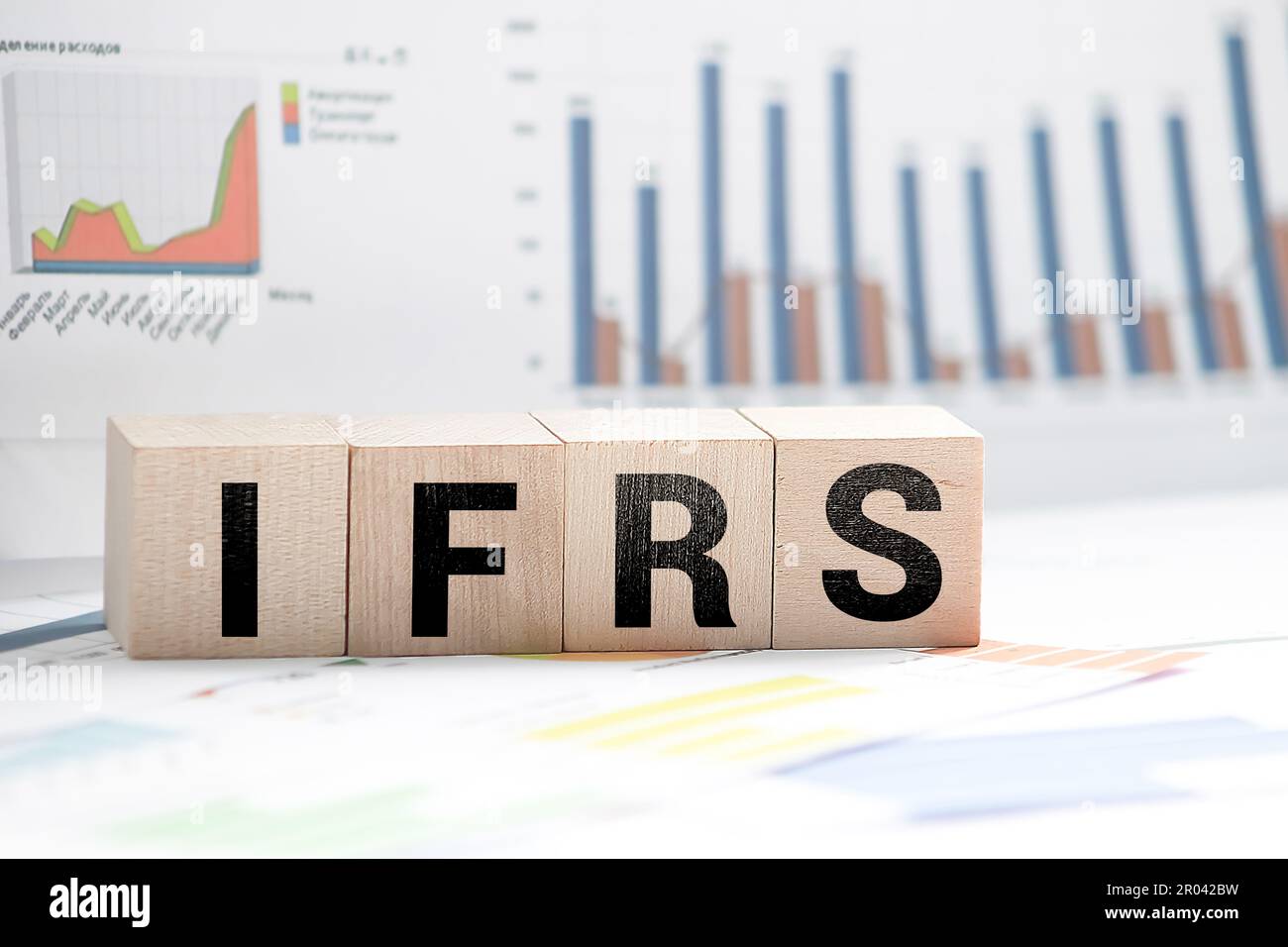 wooden cubes with the word IFRS on financial background with chart ...