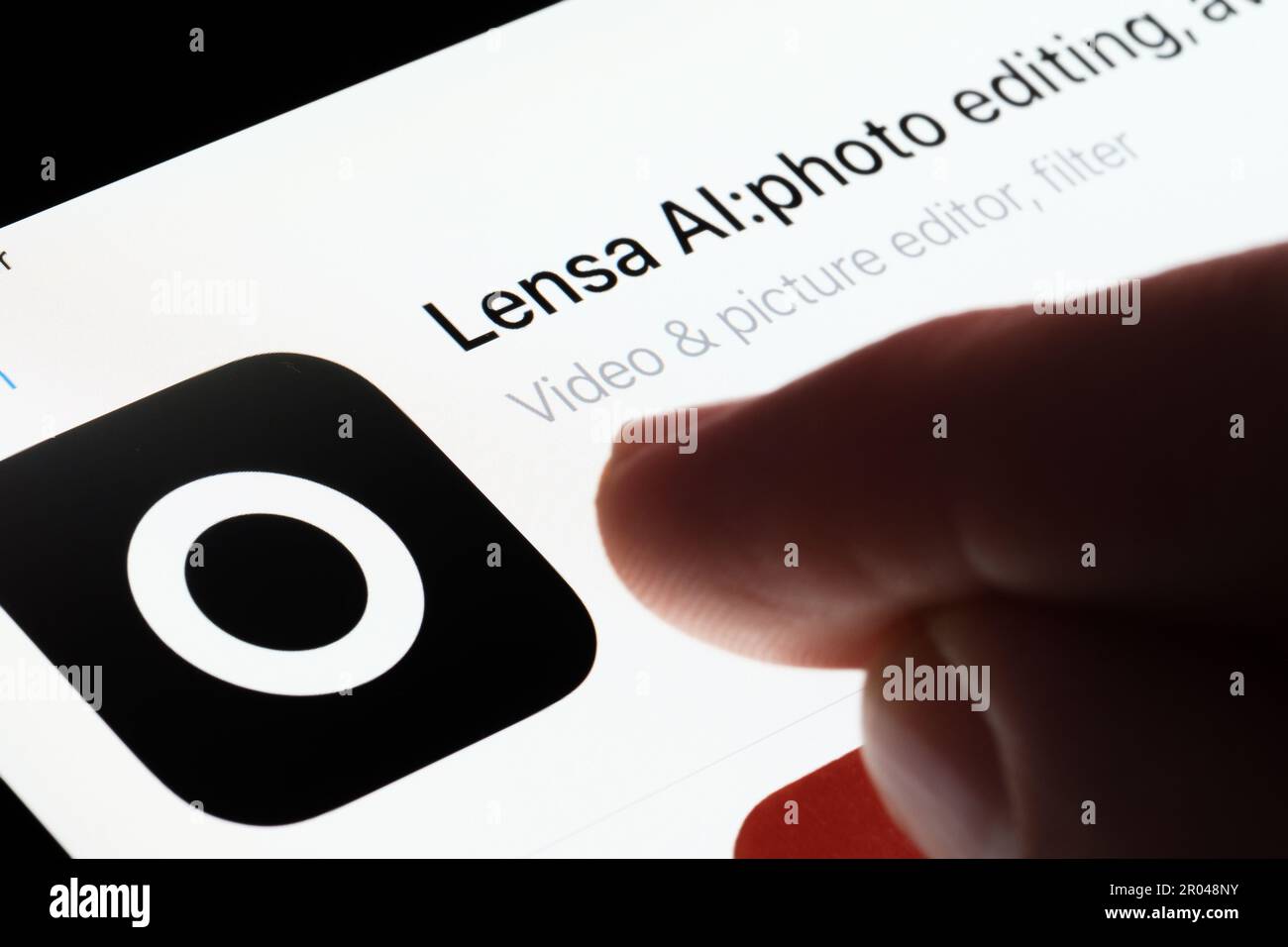 Lensa AI app seen in App Store on the screen of ipad and blurred finger ...