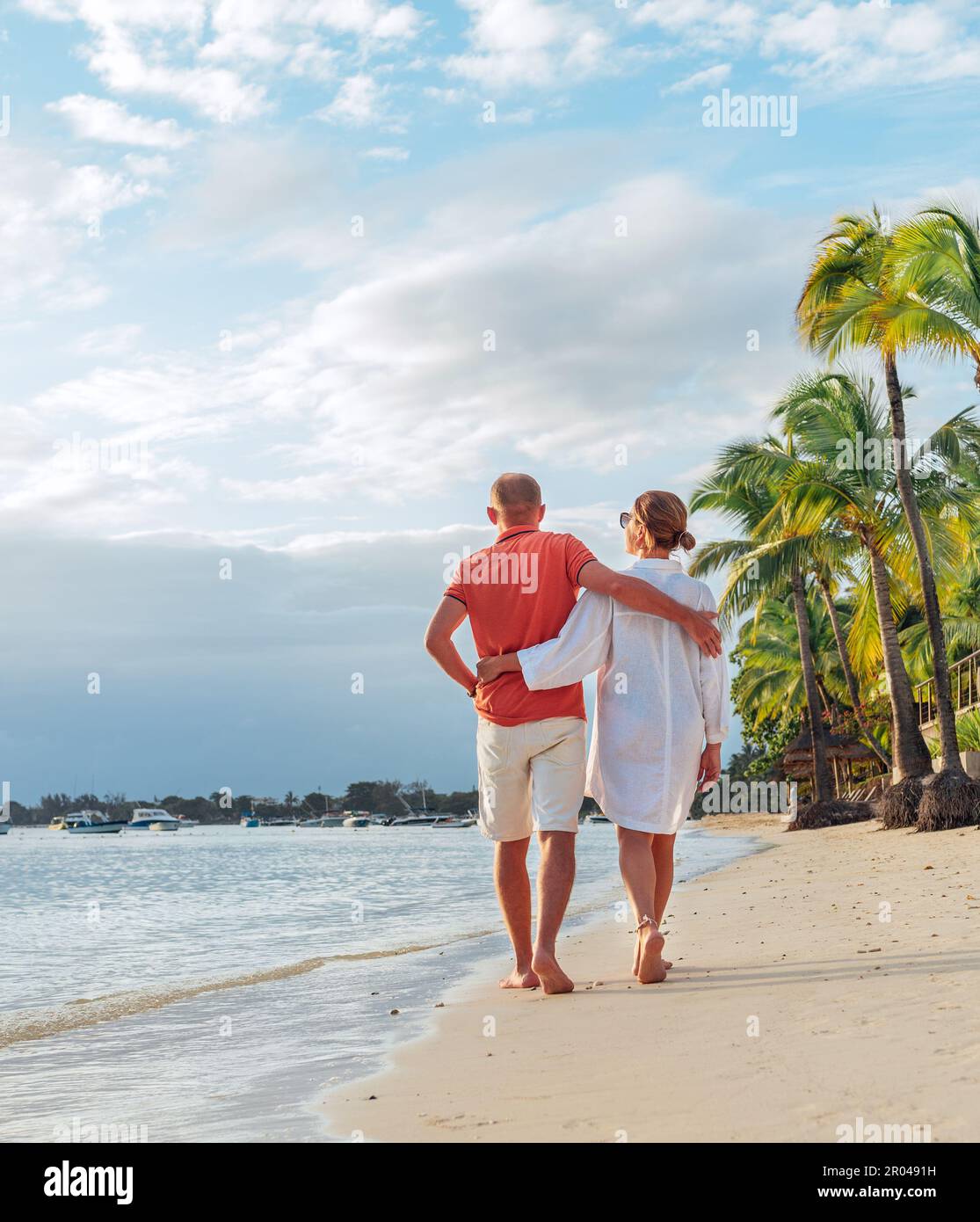 Couple in love hugging while walking on a sandy exotic beach. They have ...