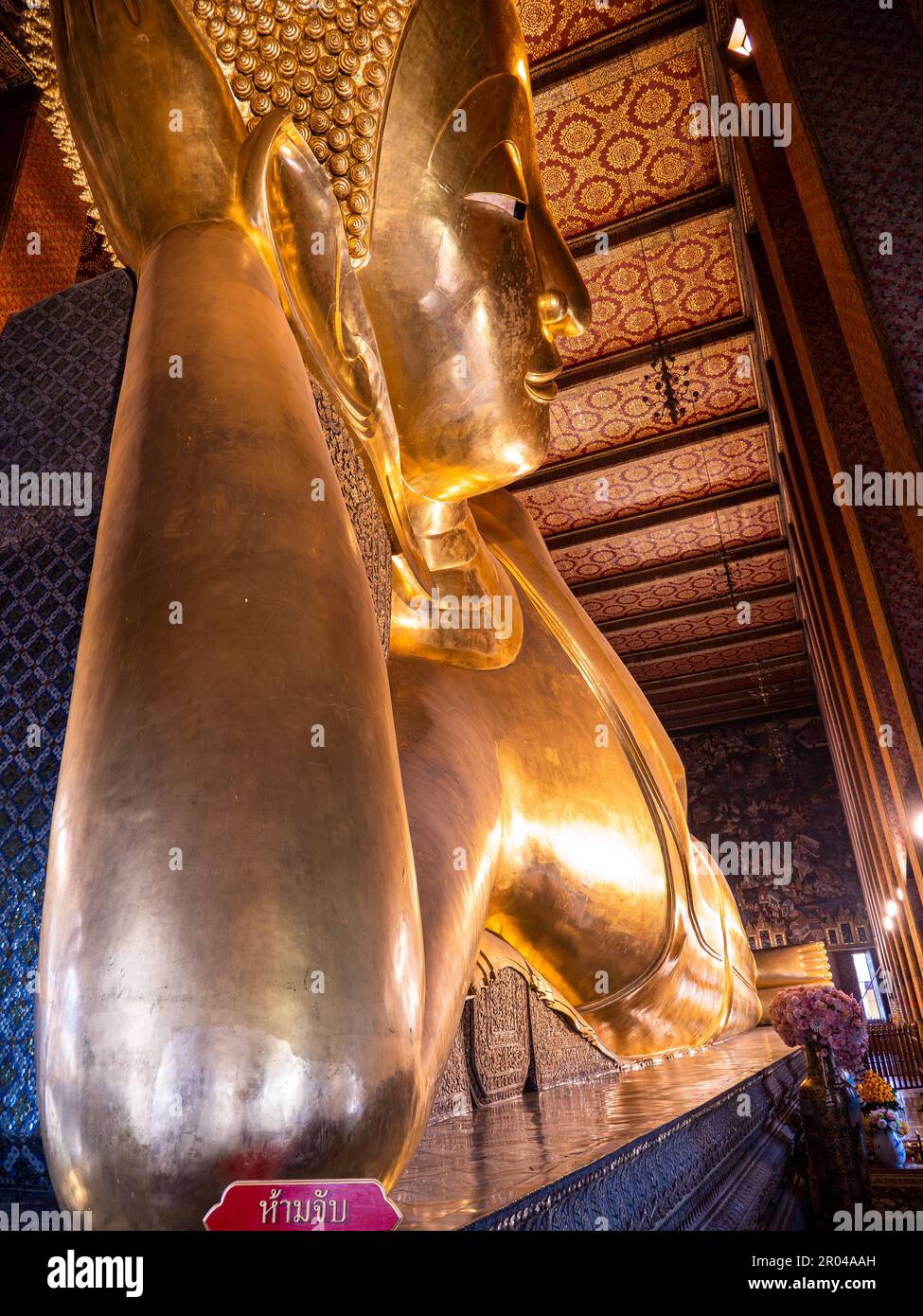 The Reclining Buddha at Wat Pho in Bangkok, Thailand, is a stunning sight. The statue is covered ...