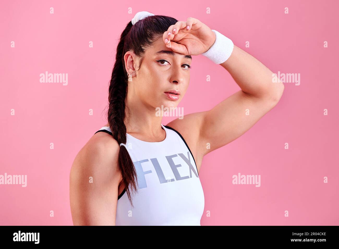 Sweat now, shine later. Studio portrait of a sporty young woman wiping ...