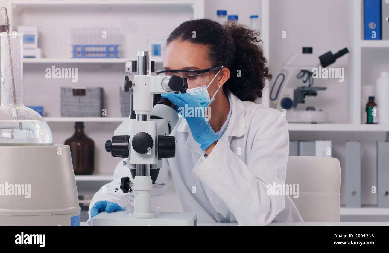 Let me take another look. a young scientist using a microscope in a lab ...