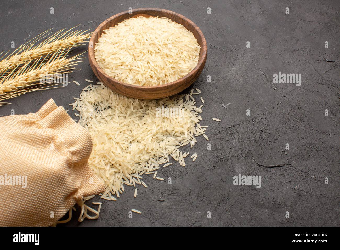 half-top view raw rice inside brown plate on dark-grey background rice ...