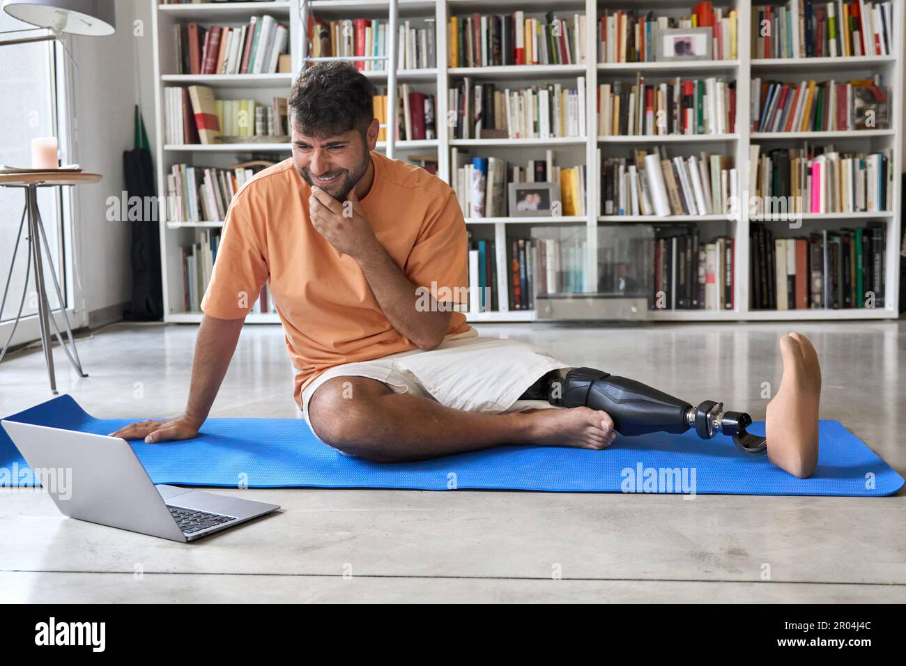 Amputee man with prosthetic leg prosthesis doing exercises at home with ...