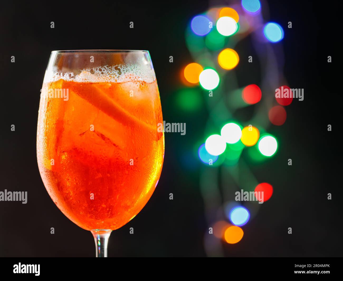 Glass of Aperol Spritz cocktail on a blurred background with colorful ...
