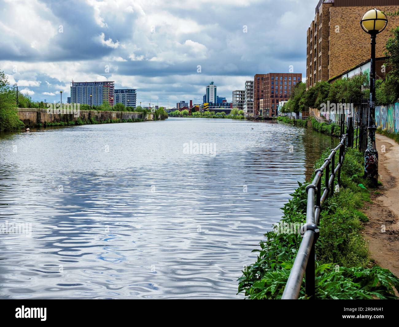 A bustling city skyline reflected in the calm waters of River Irwell ...
