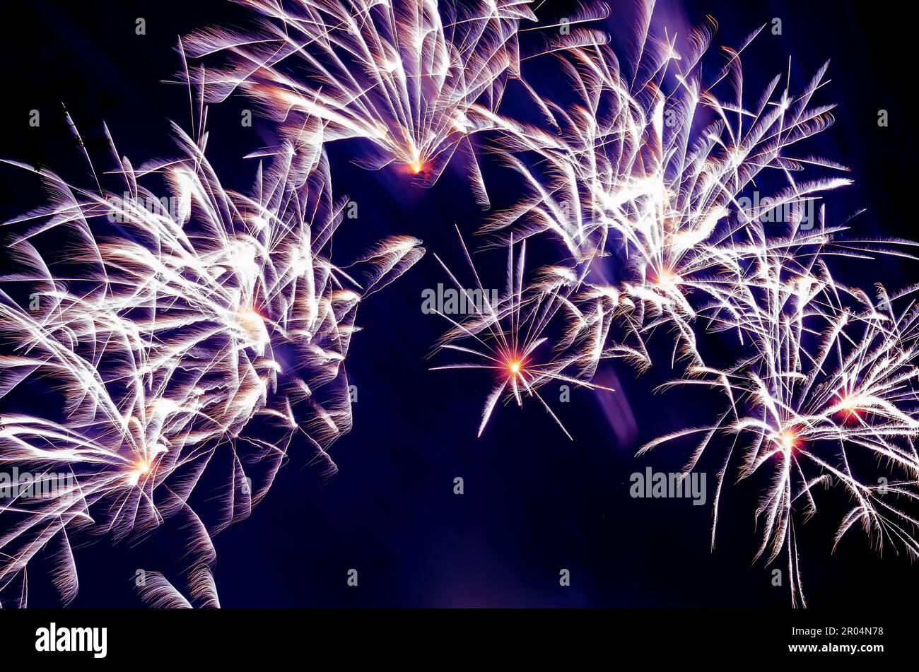 Festive New Year's fireworks. Bright beams of bursting fireworks against dark background of ...