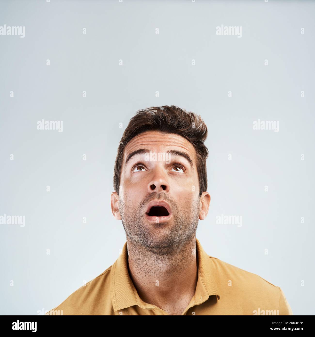 Wow thats big. Studio shot of a young man with a confused facial ...