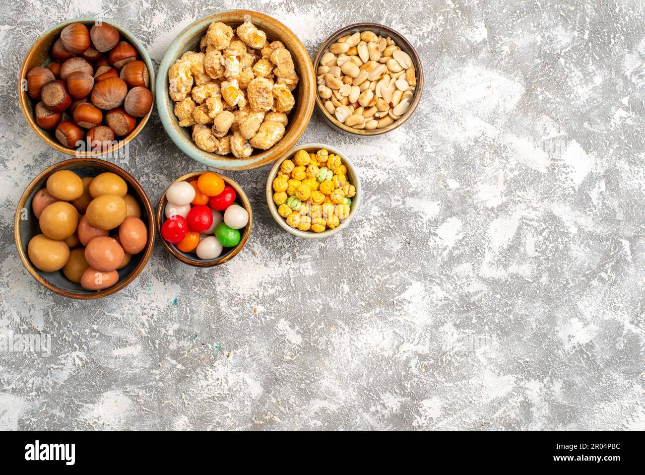 top view hazelnuts and peanuts with candies on white background nuts ...