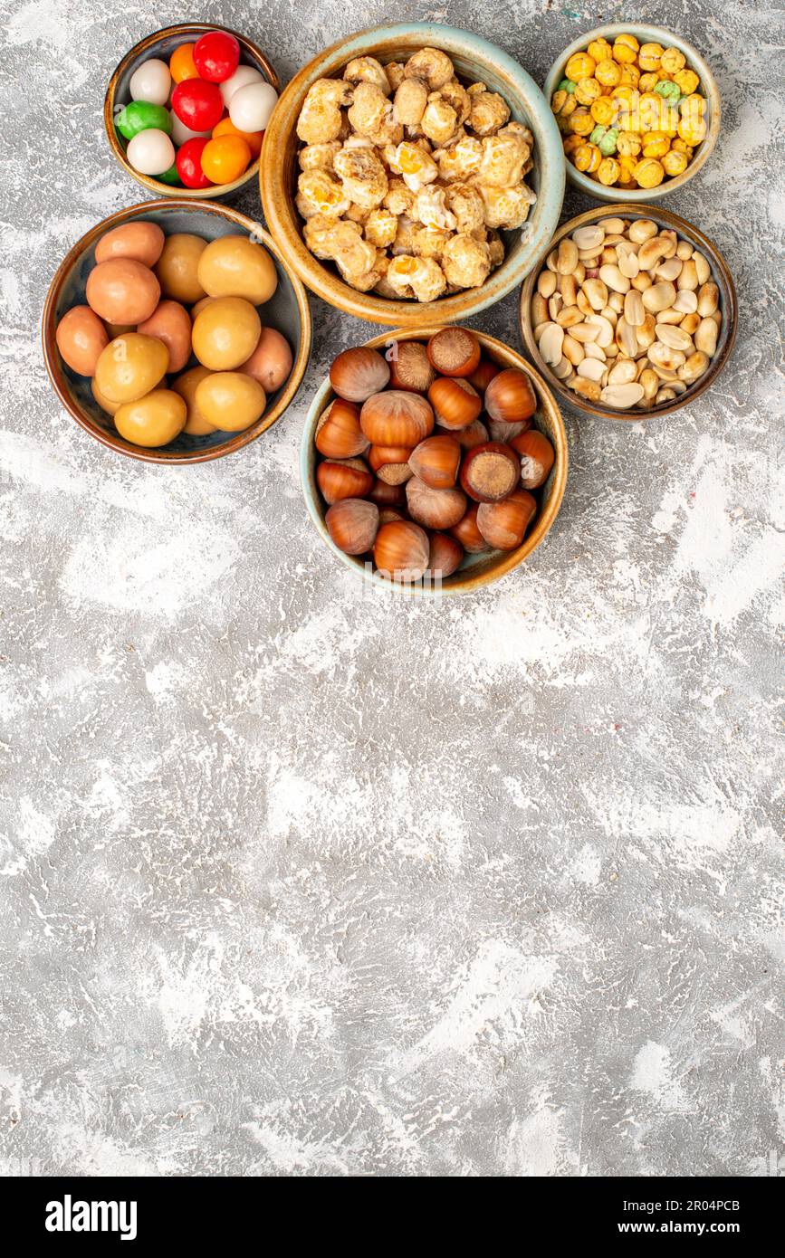 top view hazelnuts and peanuts with candies on white background nut ...