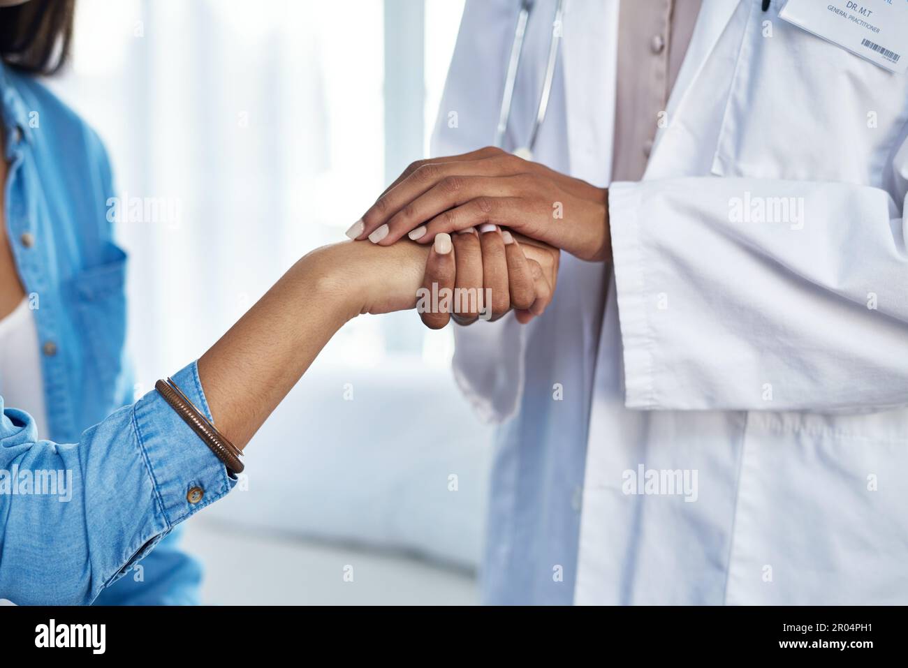 This is a safe space. a doctor holding hands with a patient in her ...