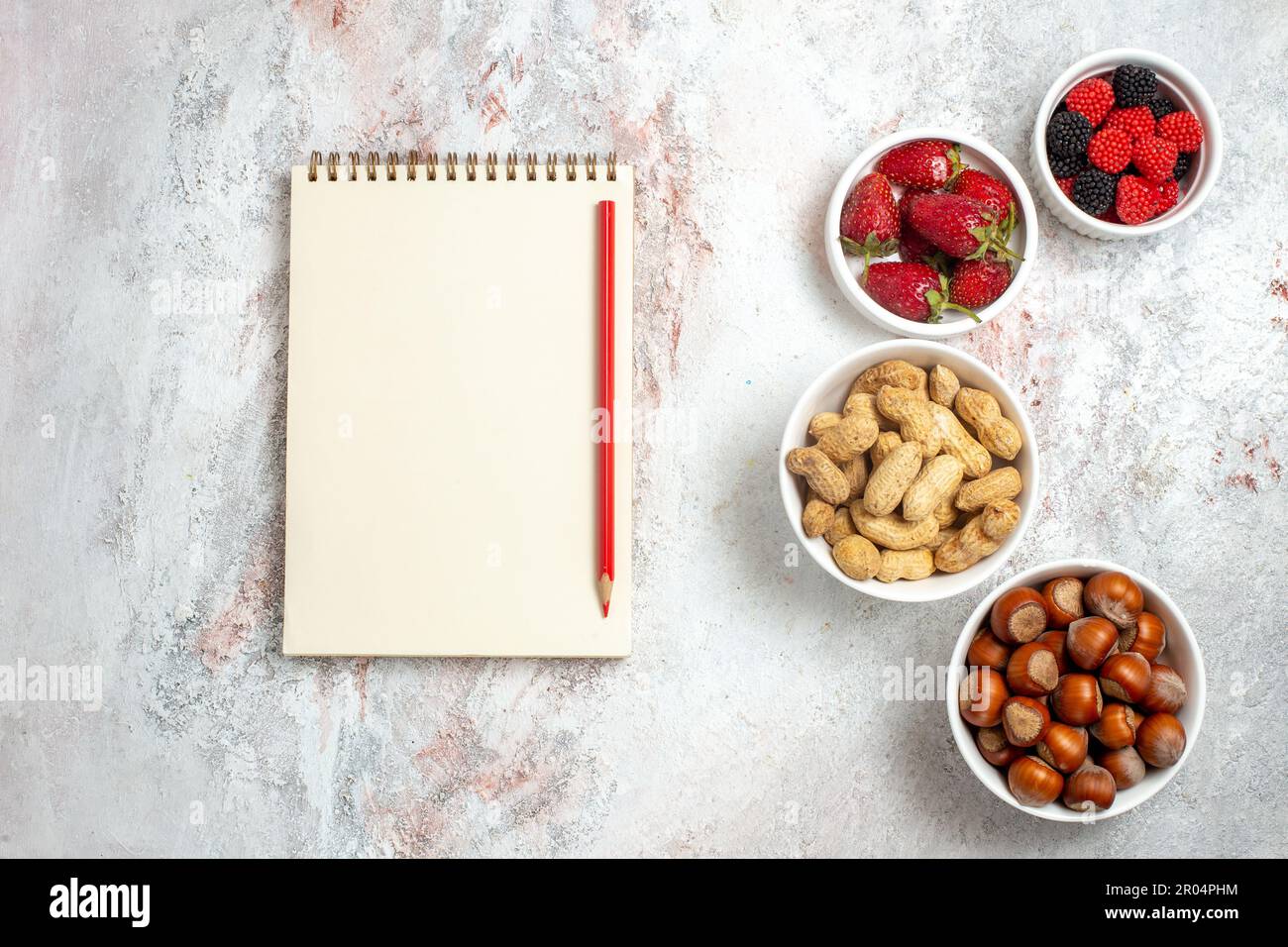 top view peanuts and hazelnuts with fresh strawberries on white desk ...