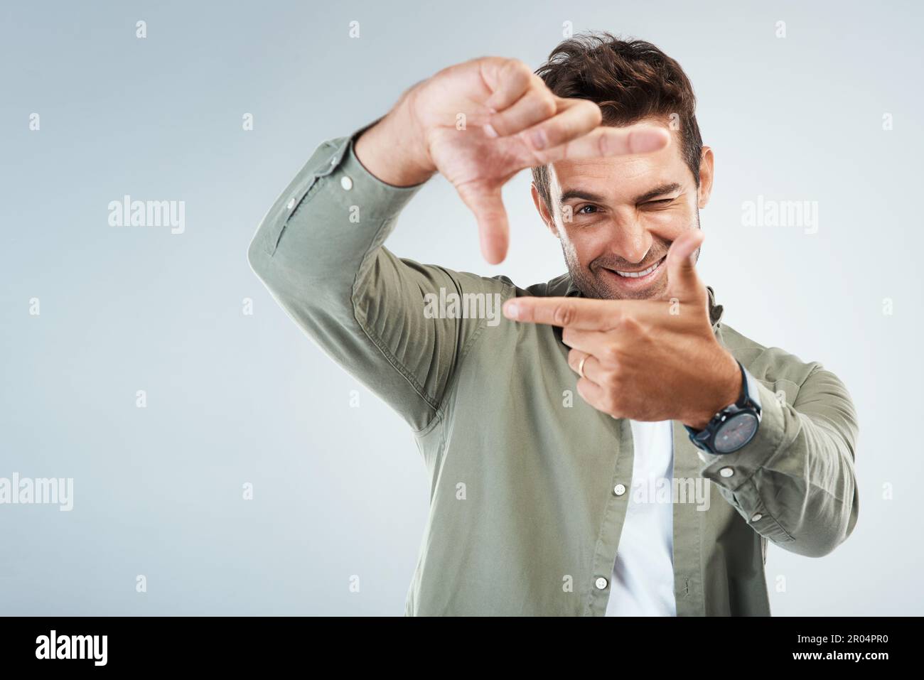 Stand still. Portrait of a cheerful young man making frames with his ...
