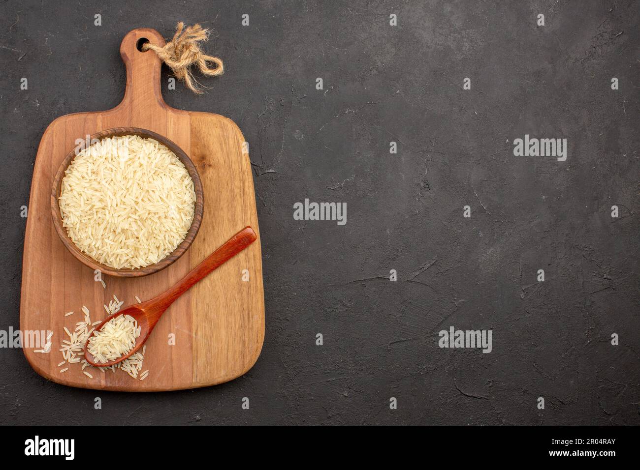 top view raw rice inside wooden brown plate on a grey background rice ...