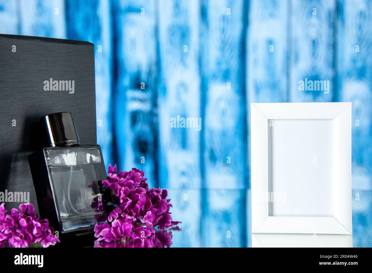 front view black expensive fragnance with picture frame on light ...