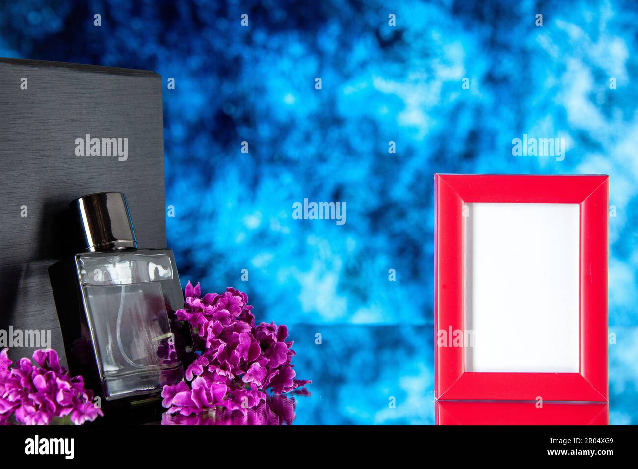 front view black fragnance with pink picture frame on a light blue ...