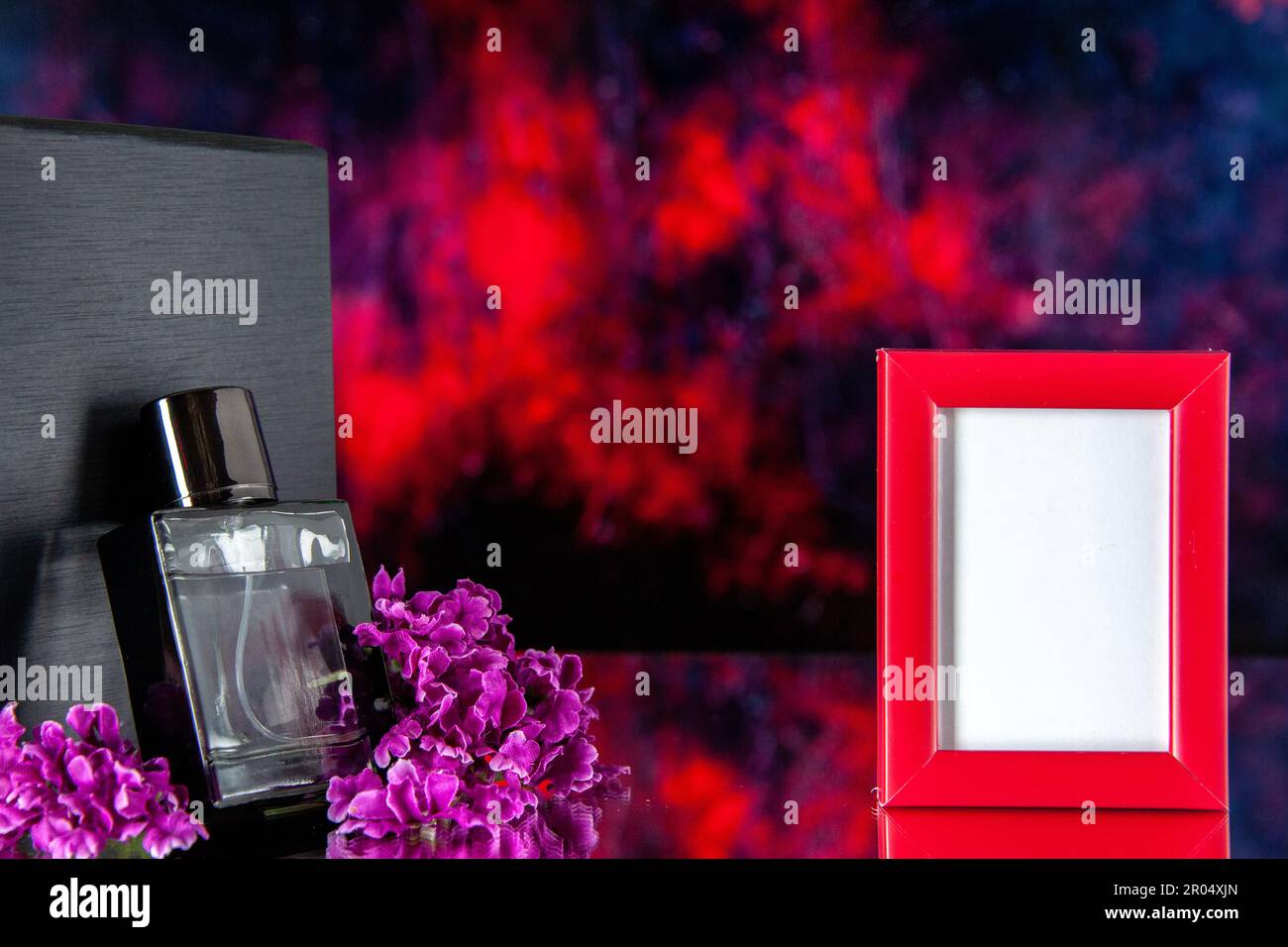 front view black fragnance with pink picture frame on dark background ...