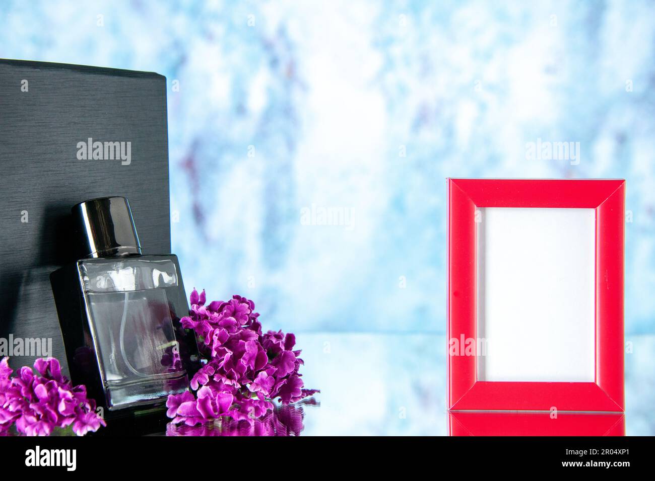 front view black fragnance with pink picture frame on light-blue ...