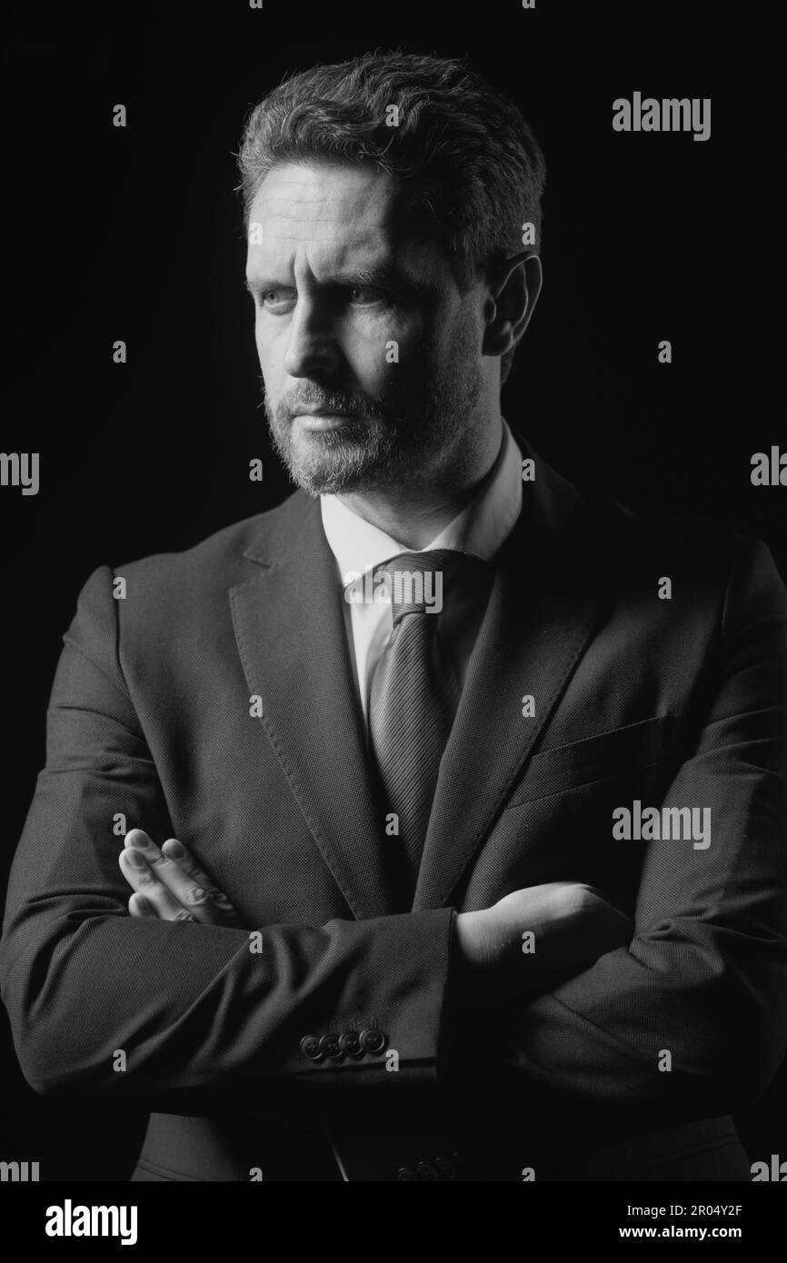 Studio portrait of serious businessman wearing suit and tie and looking ...