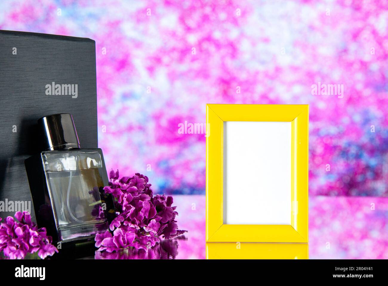 front view black fragnance with yellow picture frame on pink background ...