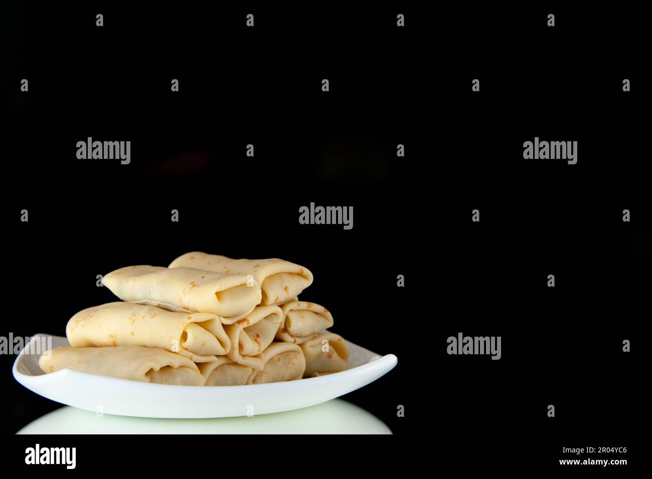 front view delicious sweet pancakes rolled inside plate on black ...