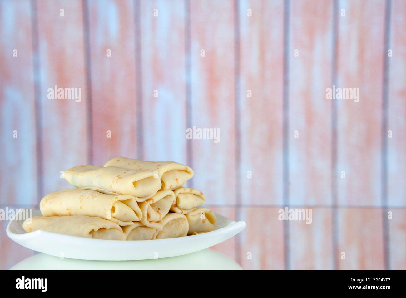 front view delicious sweet pancakes rolled inside plate on light ...