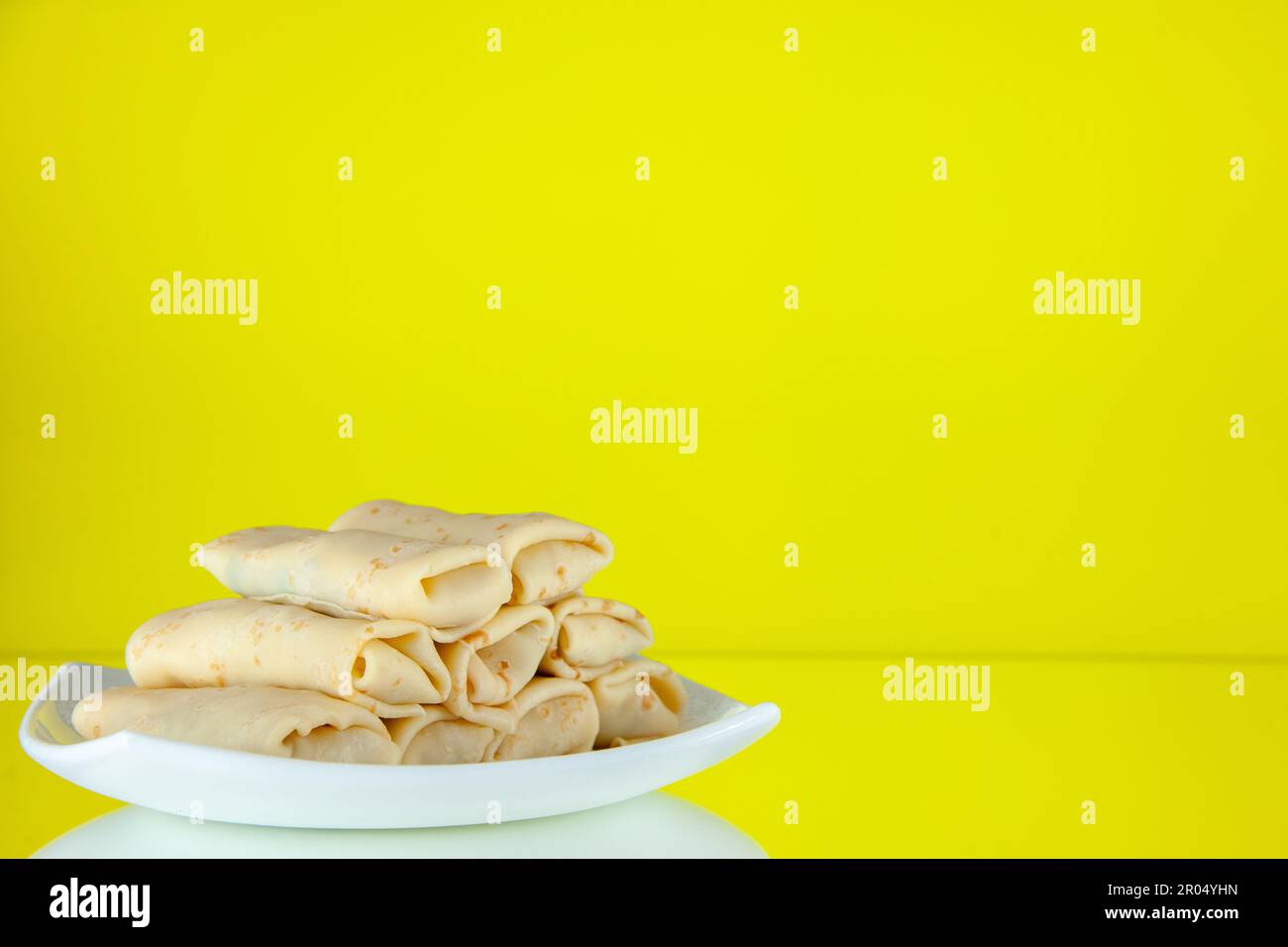 front view delicious sweet pancakes rolled inside plate on yellow ...