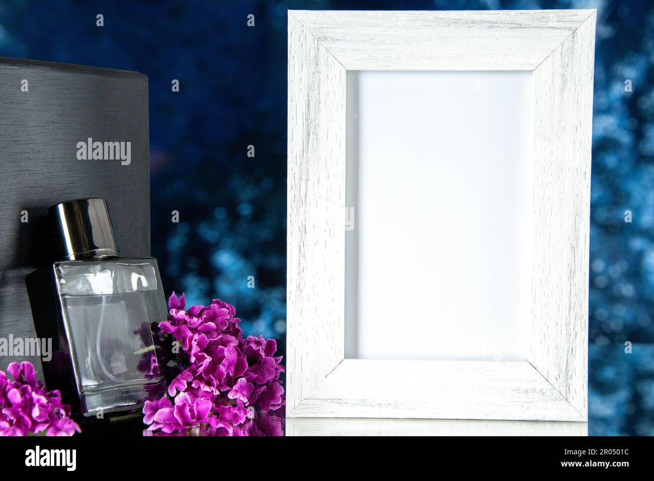 front view expensive fragnance with picture frame on dark blue ...