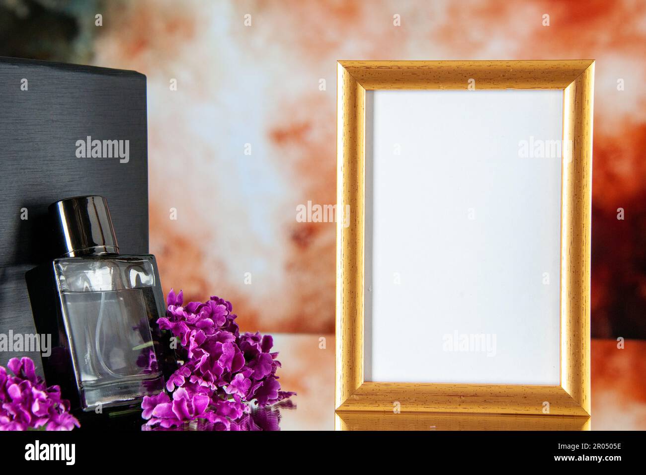 front view expensive fragnance with picture frame on light brown ...