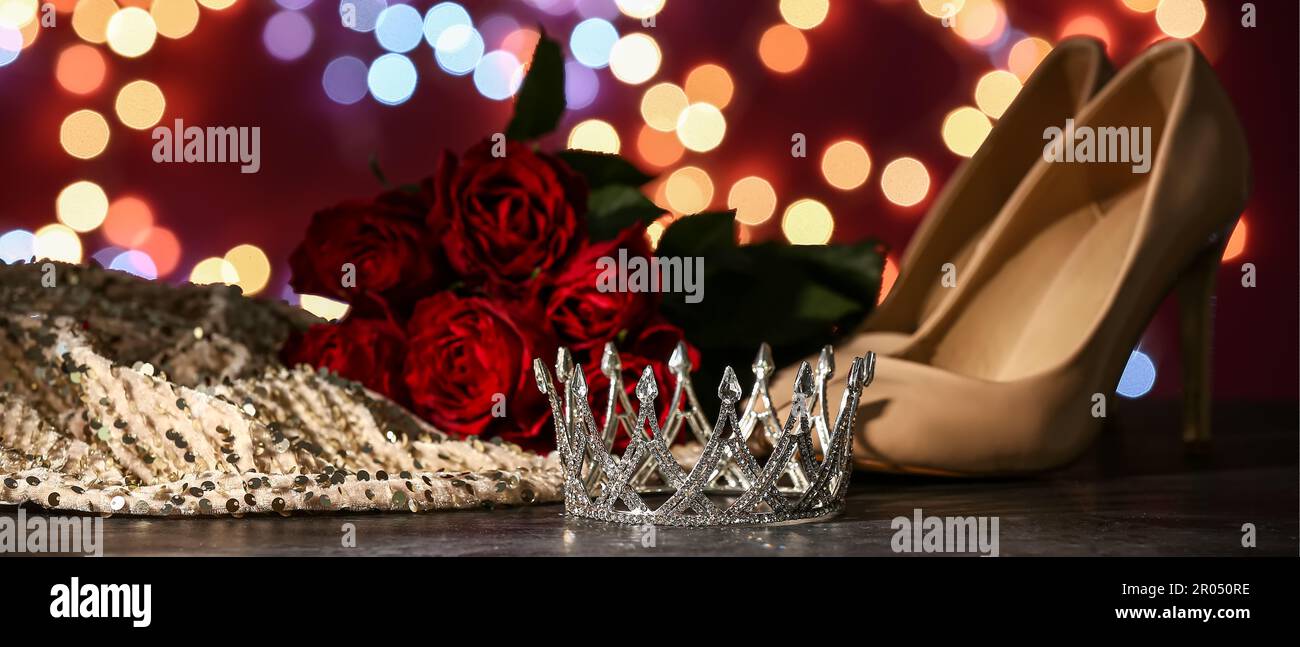 Crown with high-heels, roses and prom dress on dark background with ...