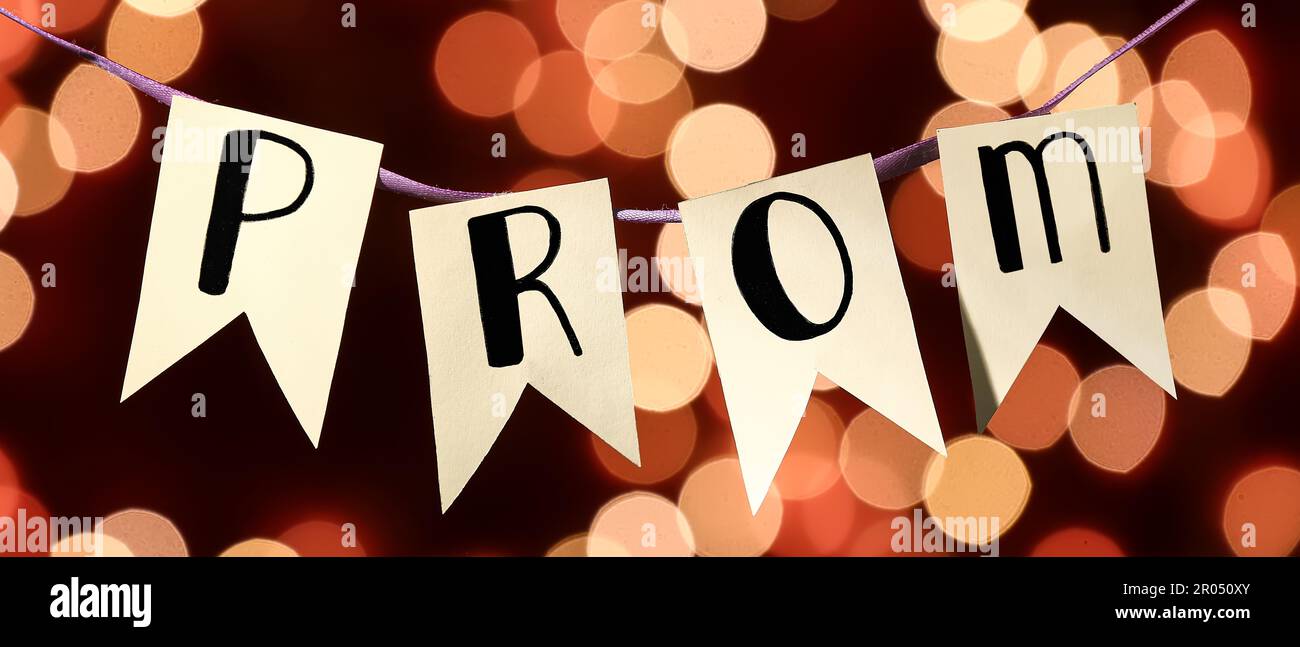 Hanging flags with word PROM on dark background with blurred lights ...