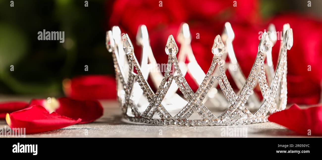 Beautiful crown with red rose petals on grunge table Stock Photo - Alamy