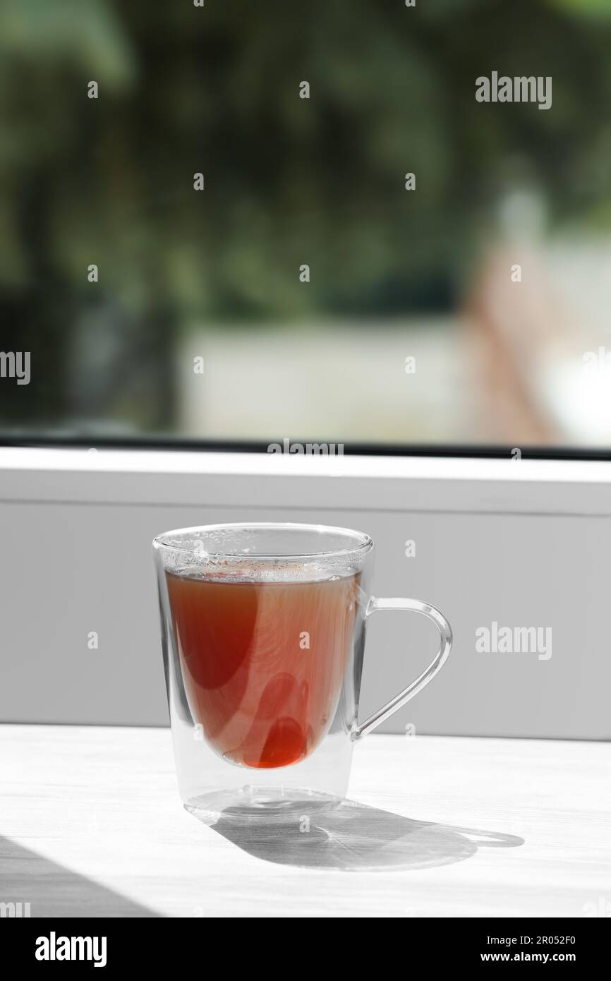 Glass cup of tea on wooden window sill Stock Photo - Alamy